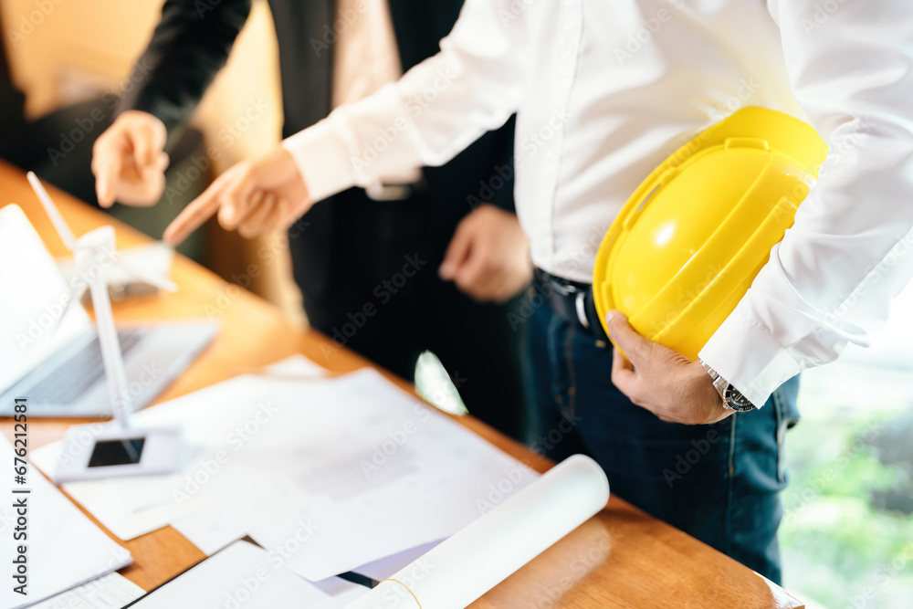 Two male engineers hold hard hats at their sides. Point to the wind ...