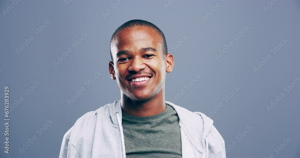 Black man, smile and thumbs up in studio, yes and positive review or feedback, agreement and ...