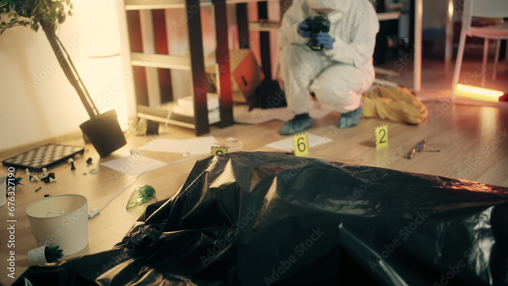 The forensic expert is taking pictures of marked evidence and examining ...