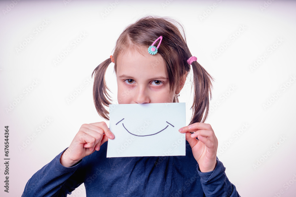 Put a smile on face! Beautiful young girl holding fingers on his mouth ...