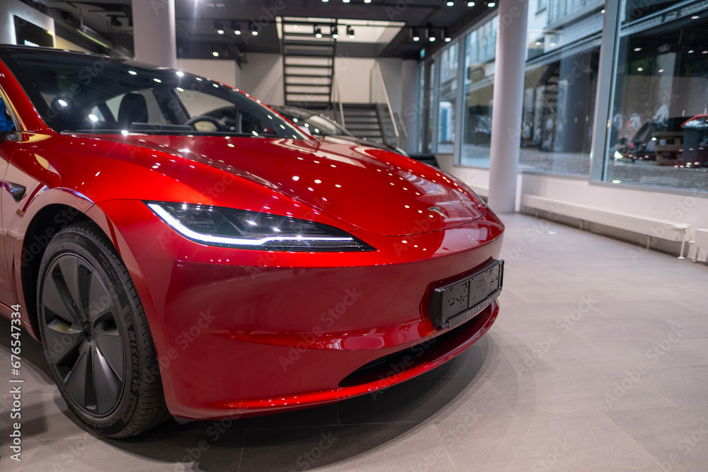 new red Tesla Model 3 electric car in showroom, trends in use EV in ...