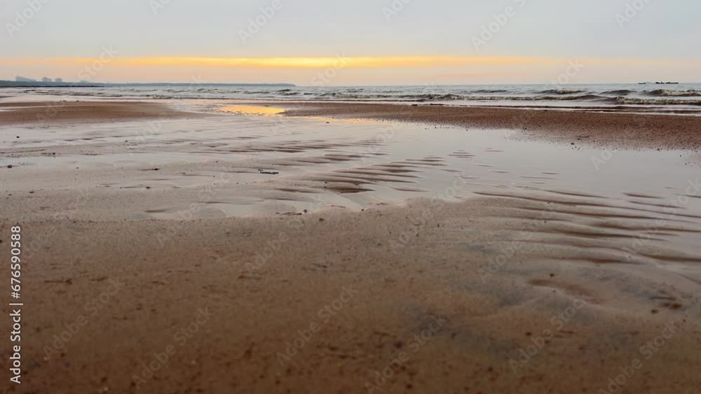 Peaceful beach scene at sunset. Delicate golden sky above sea waves ...