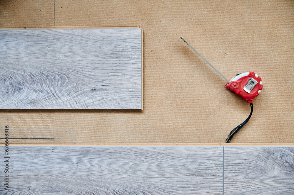 Tape measure and wooden flooring planks for home renovation ...