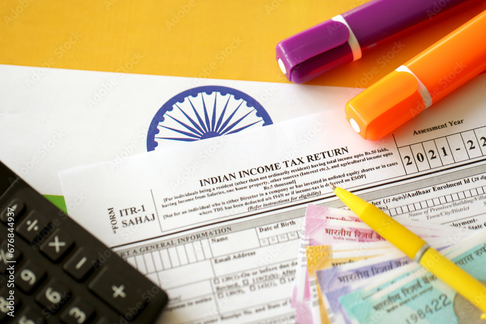 Indian income tax return blank form with pen and indian rupees bills on ...