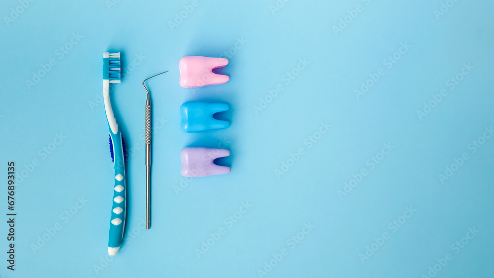 Three multi-colored models of teeth on a blue background. Dental probe ...