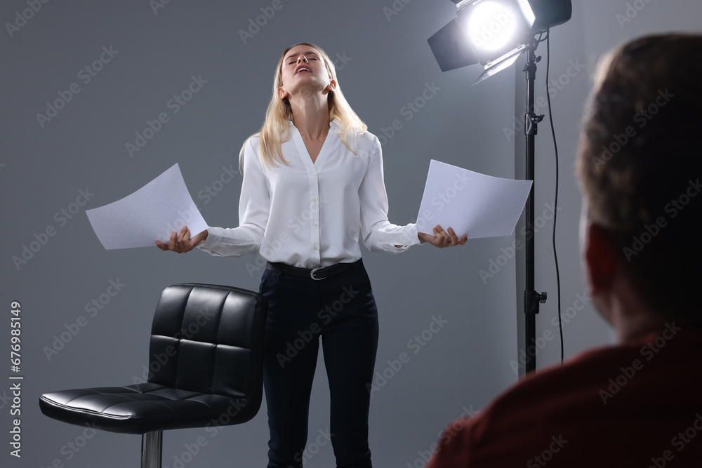 Emotional woman with script performing in front of casting director ...