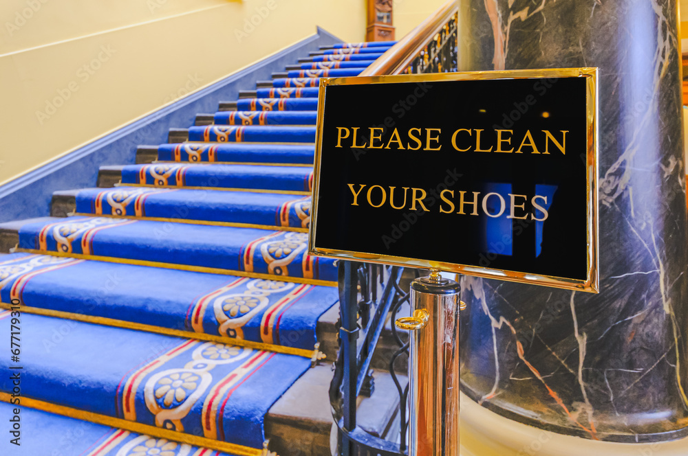 Sign saying "Please clean your shoes" at the bottom of a flight of ...