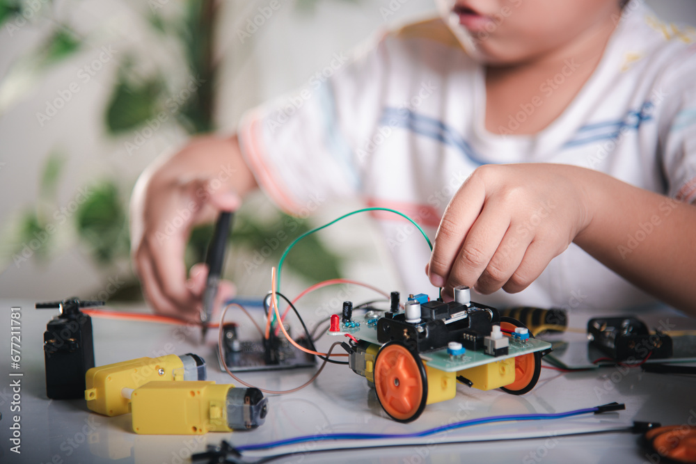 Little child remotely learn online with car toy before sent code, Asian kid boy plugging energy ...