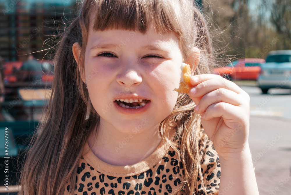 Little adorable girl holding a chicken in her hands, eating in fast ...