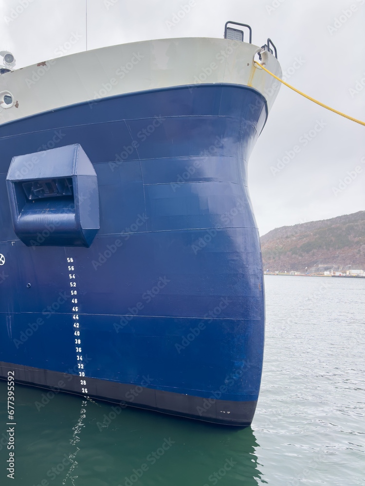 The front of a large blue and white colored ship. The hull of the bow ...