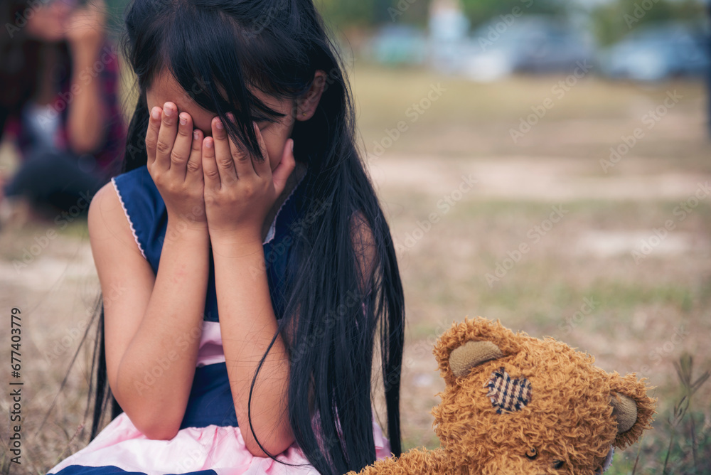 Sad girl hugging teddy bear sadness alone in green garden park. Lonely ...