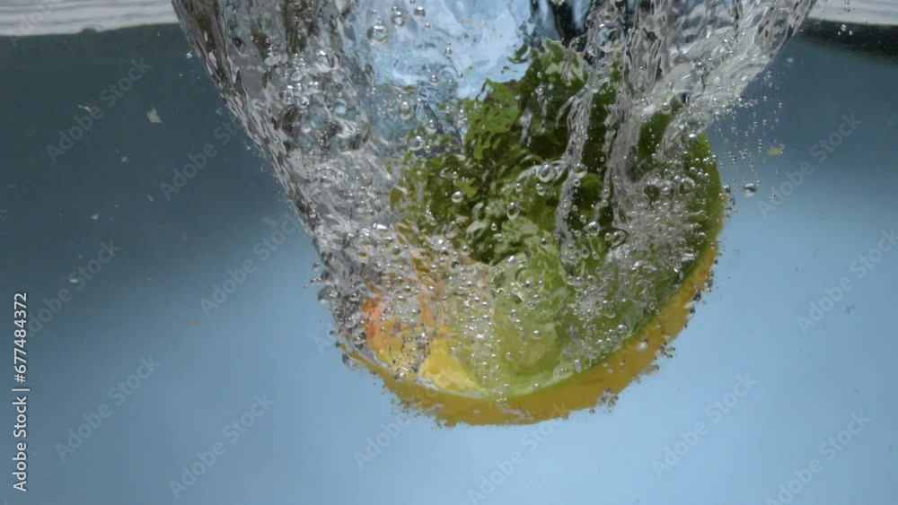 Mango falling into water in super slow motion with blue background ...