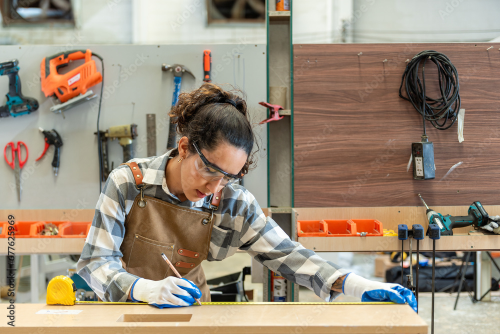 Carpenter woman one smile young aged standing aim working on wood plank ...