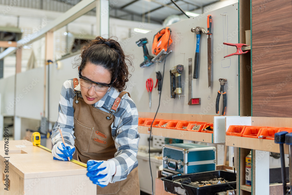 Carpenter woman one smile young aged standing aim working on wood plank ...