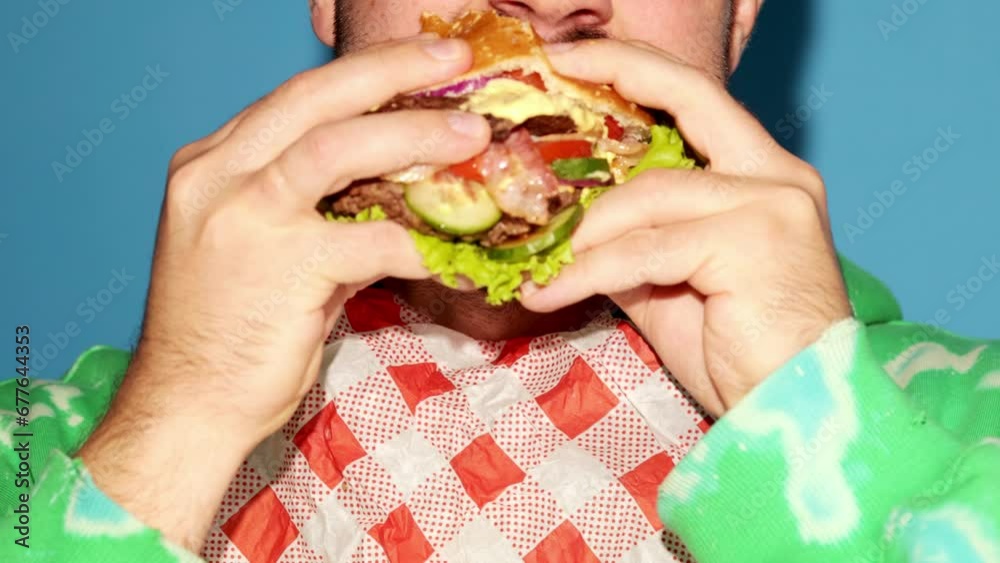 Cropped male face. Man biting delicious burger with meat, bacon, cheese ...