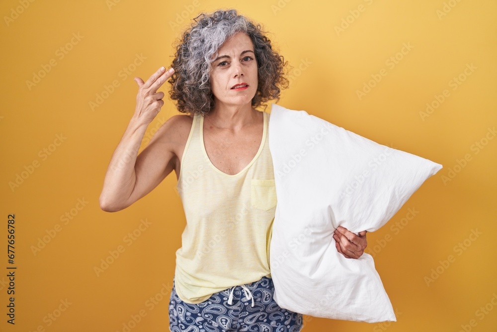 Middle age woman with grey hair wearing pijama hugging pillow shooting ...