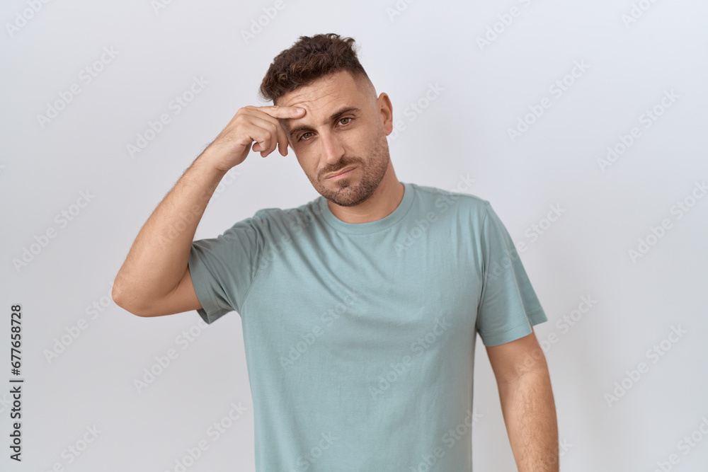 Hispanic man with beard standing over white background pointing unhappy ...