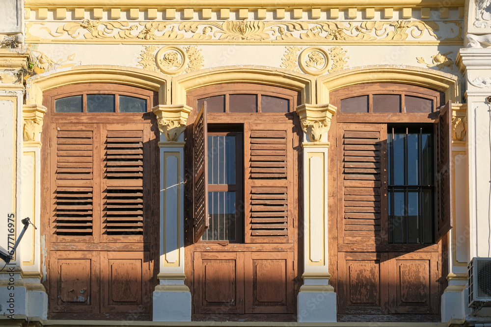 The facade ornament design and big wooden panel window of a heritage ...