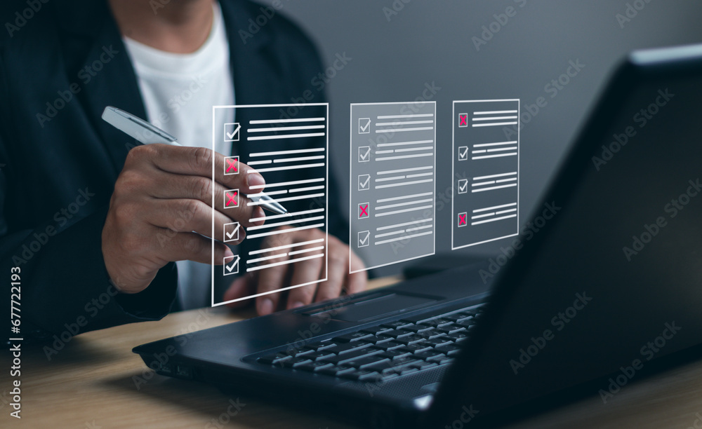 man uses pen to tick checkboxes on business performance checklist on ...