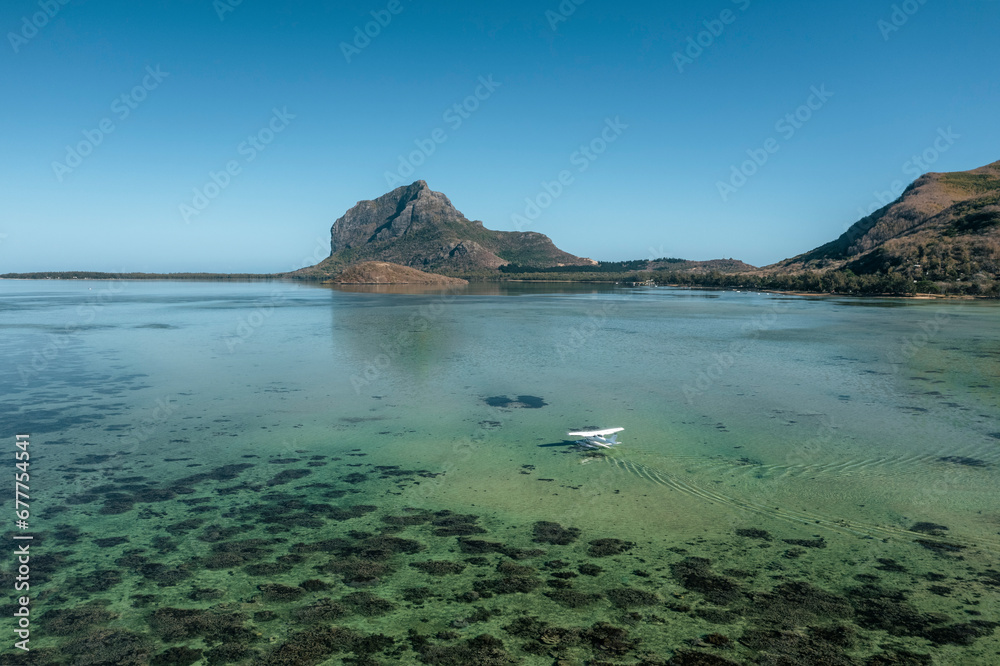 Aerial view of a water airplane landing in a lagoon with barrier reef ...