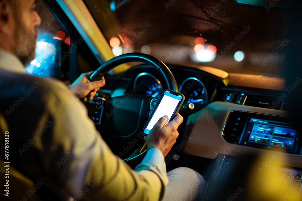 Back view man driving car checking smartphone at traffic stop Stock ...