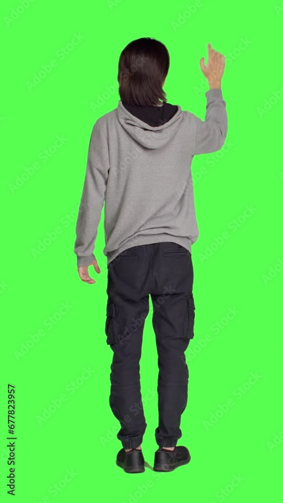 Back view of male model looks at hologram icon on camera with full body ...