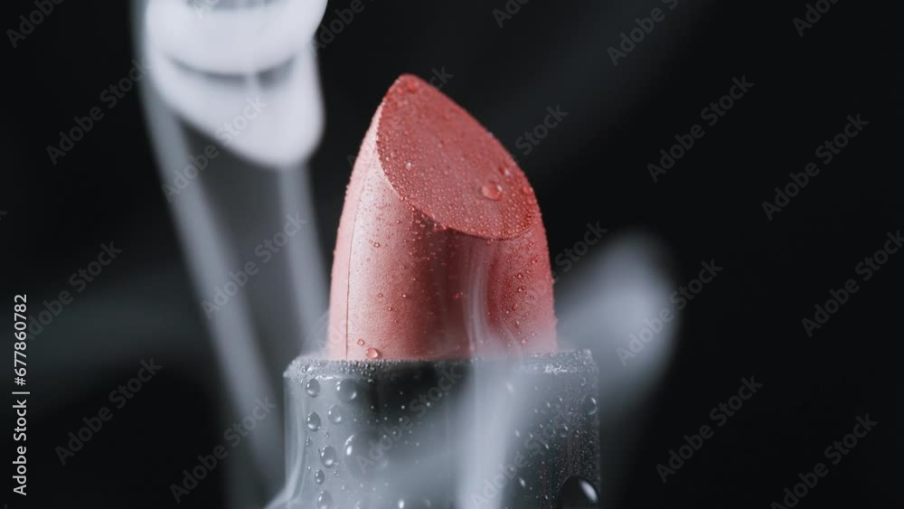 Red lipsticks make up close up background with smoke and water drops ...