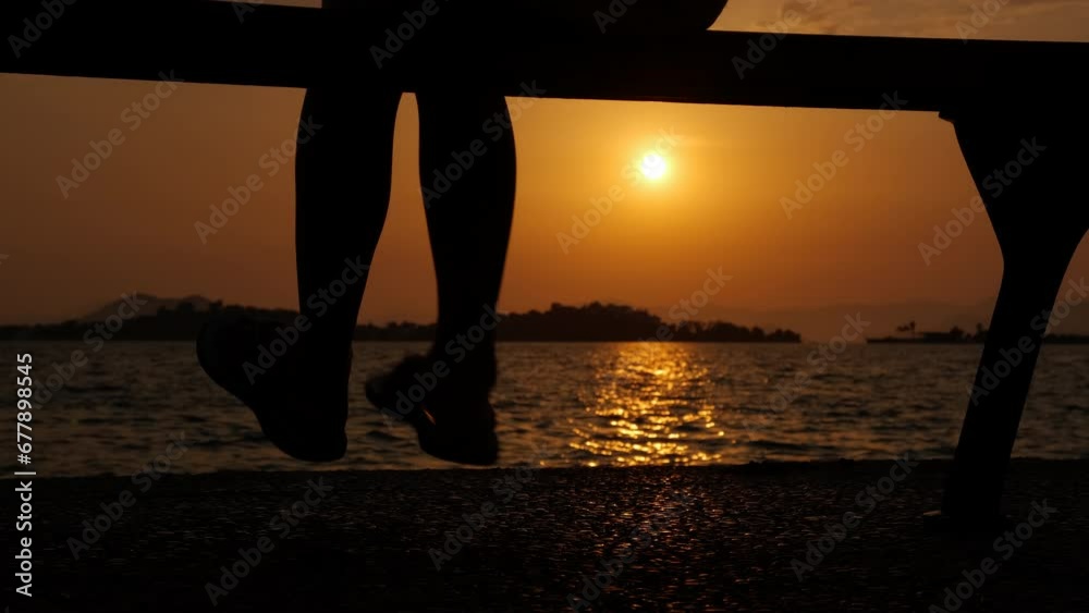 Wiggles legs silhouette on beach. A teen legs silhouette wiggles feet ...
