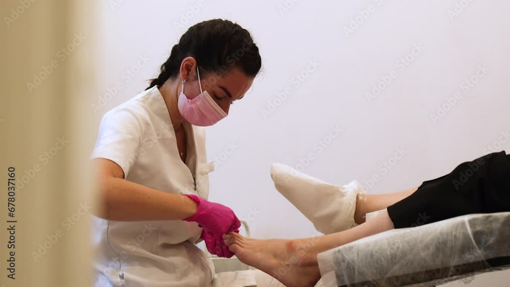 Pedicure master in medicine mask cutting of cuticle nails of feet ...