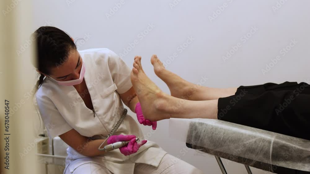 Pedicure master in medicine mask making pedicure of feet. Woman legs In ...