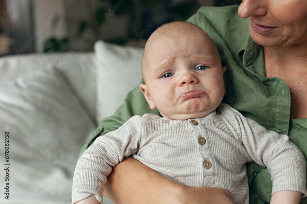 Sad baby pouting lips in mothers arms Stock Photo | Adobe Stock