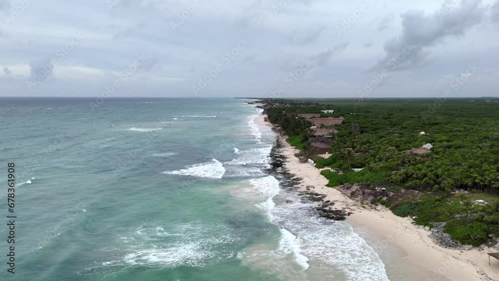 Drone view of Tulum white sand beach with big waves and tropical green ...