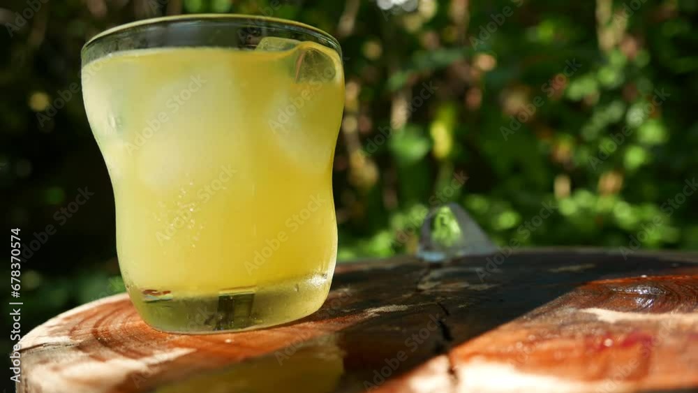 Fruit juice mixing by itself in a glass filled with ice. A big glass of ...