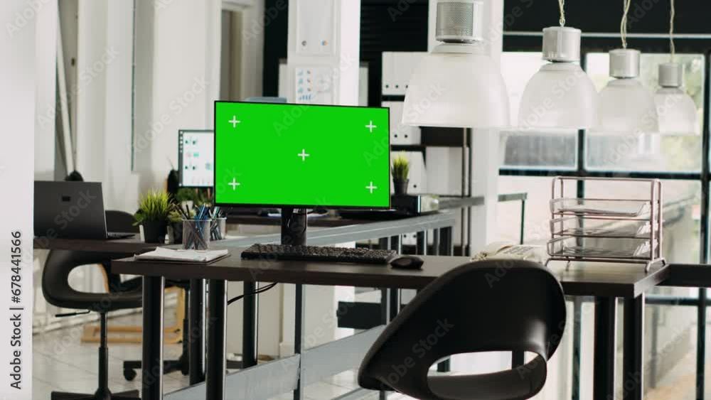 Greenscreen monitor in coworking space running on desk, open floor plan ...