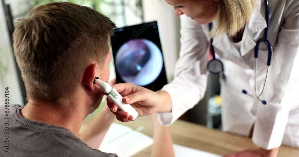 Adult male during ear examination at hearing clinic. Audiologist ...