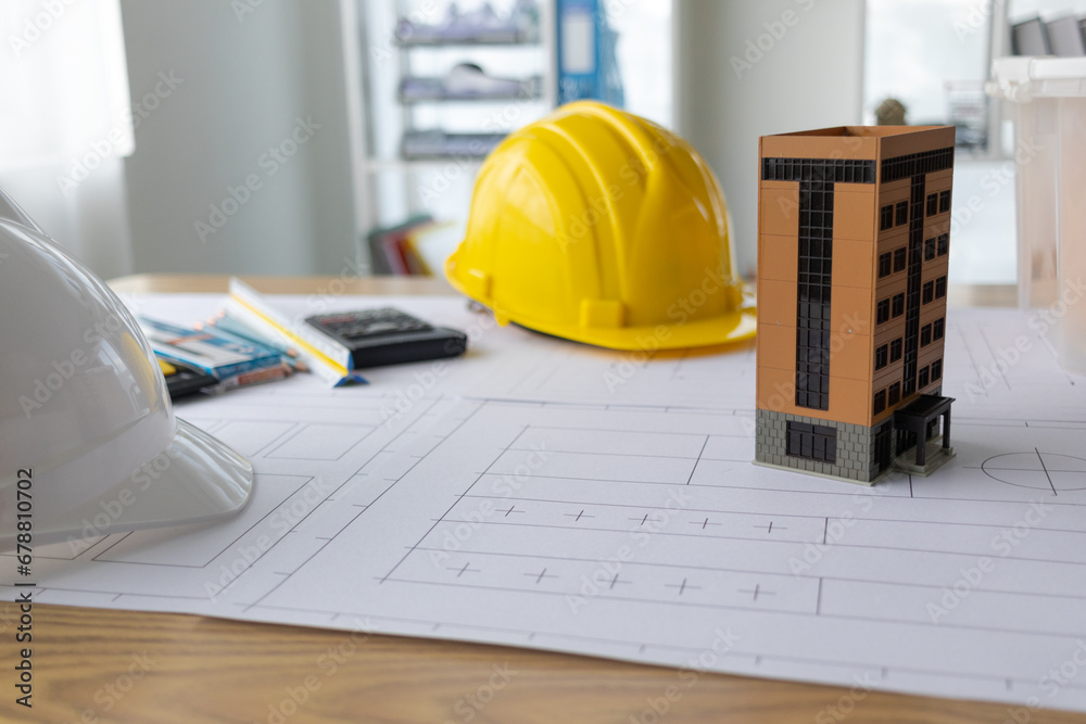 Building models and blueprints are placed on work desks in the ...