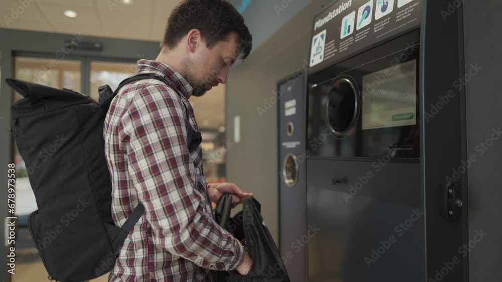 A man returns plastic bottles in a German supermarket. Reverse vending ...
