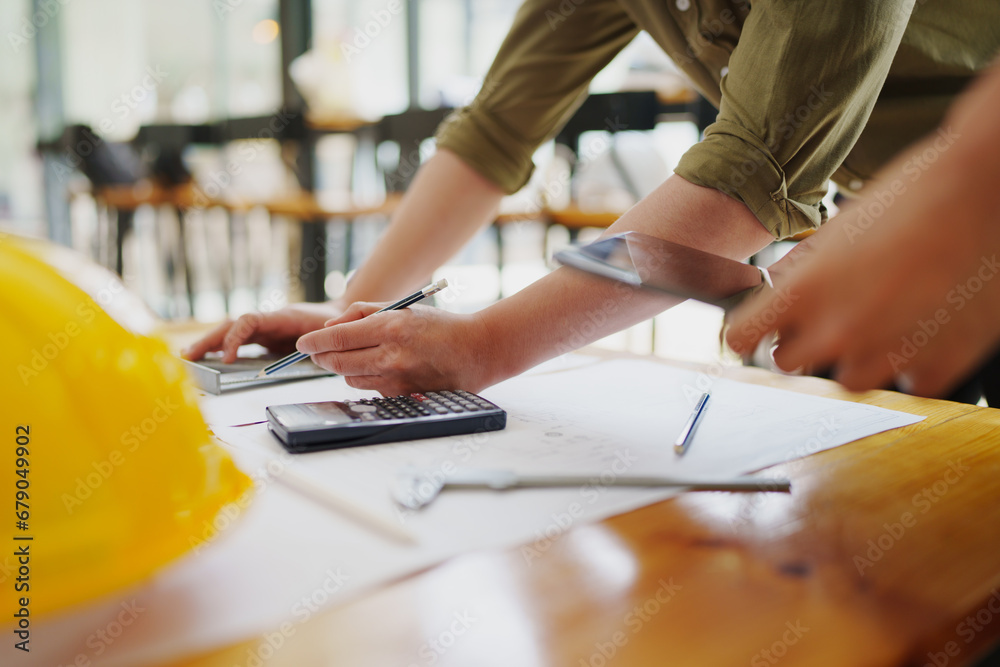 multi ethnic engineer brainstorming and measuring for cost estimating ...