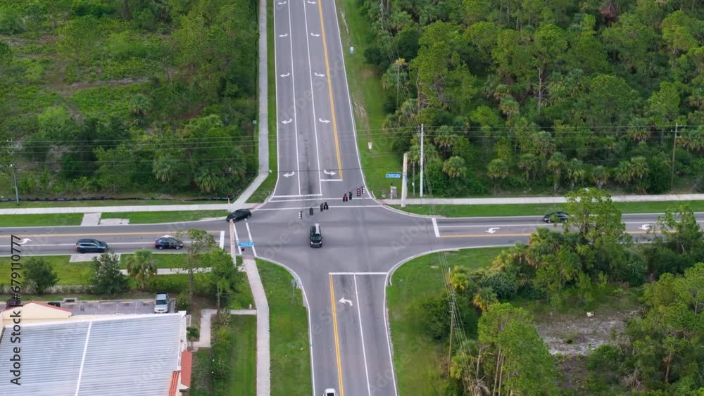 Suburban road with driving vehicles at intersection with traffic lights ...