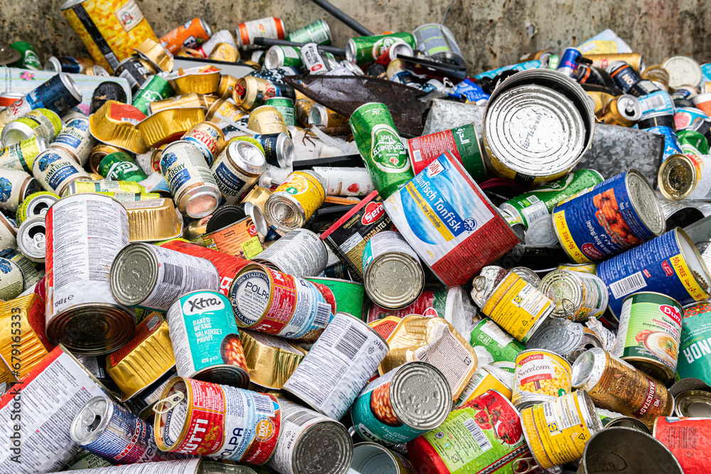 A lot of used tin cans and bottles and other packagings in trash bin ...