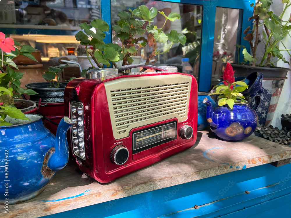 vintage radio tape and flowers in retro enamel tea pots on window sill ...