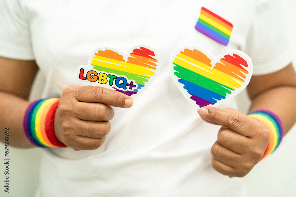 Asian lady wearing rainbow flag wristbands and hold heart, symbol of ...