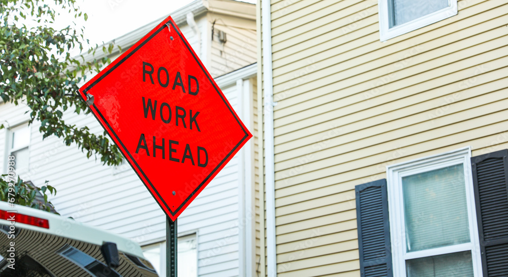 orange construction sign against a blue sky, symbolizing progress and ...