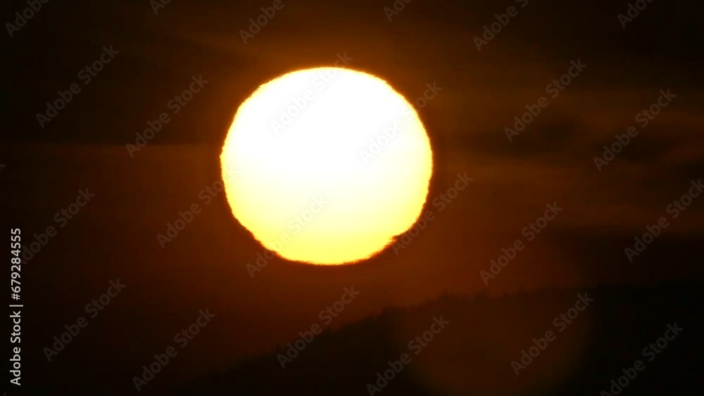 Dark sky and yellow sun during sunrise over horizon of mountains with ...