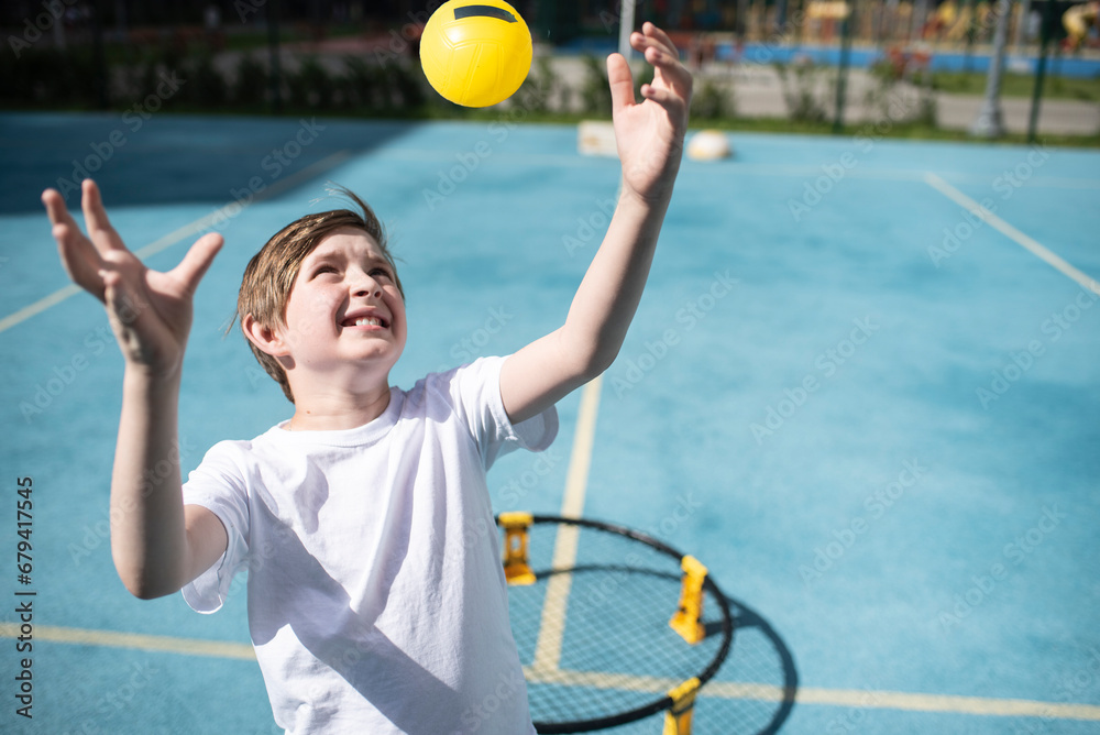 child playing sports game spikeball, spikeball. the boy is hitting the ...