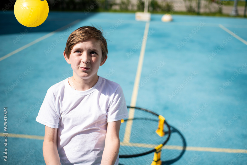 child playing sports game spikeball, spikeball. the boy is hitting the ...