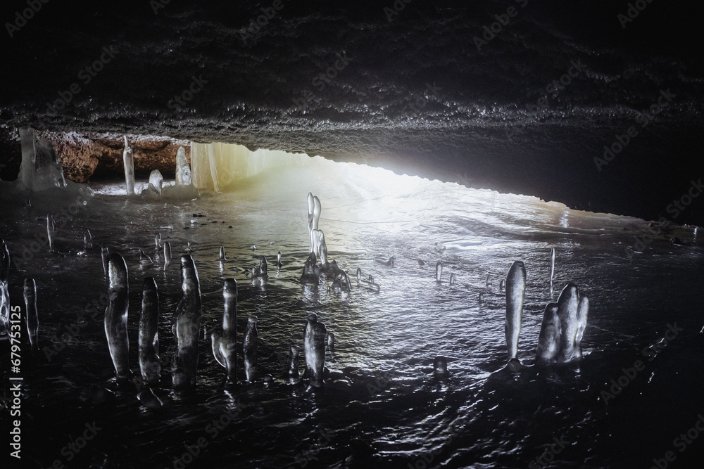An underground cave covered with ice, ice stalagmites growing in the ...