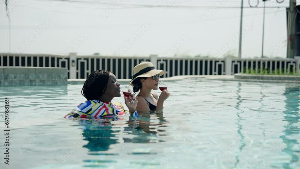 Hispanic woman with African woman stand with their back against edge ...