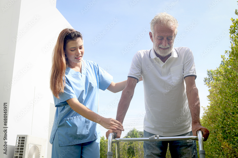Female nurse or doctor help elderly patient lean to walk with ...