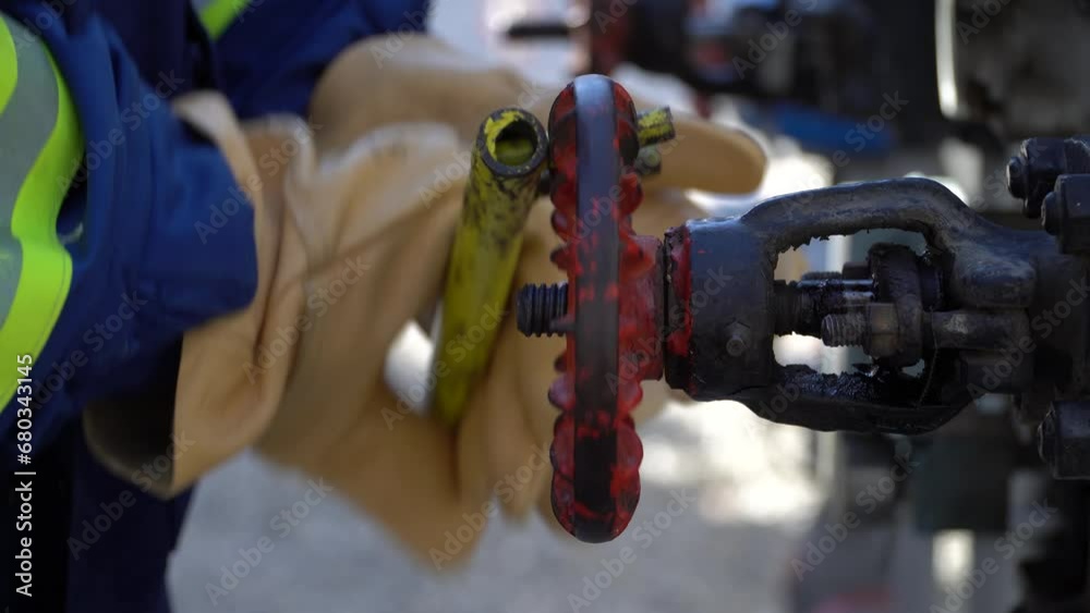 Worker turning the cap and opening the valve of circular industrial ...